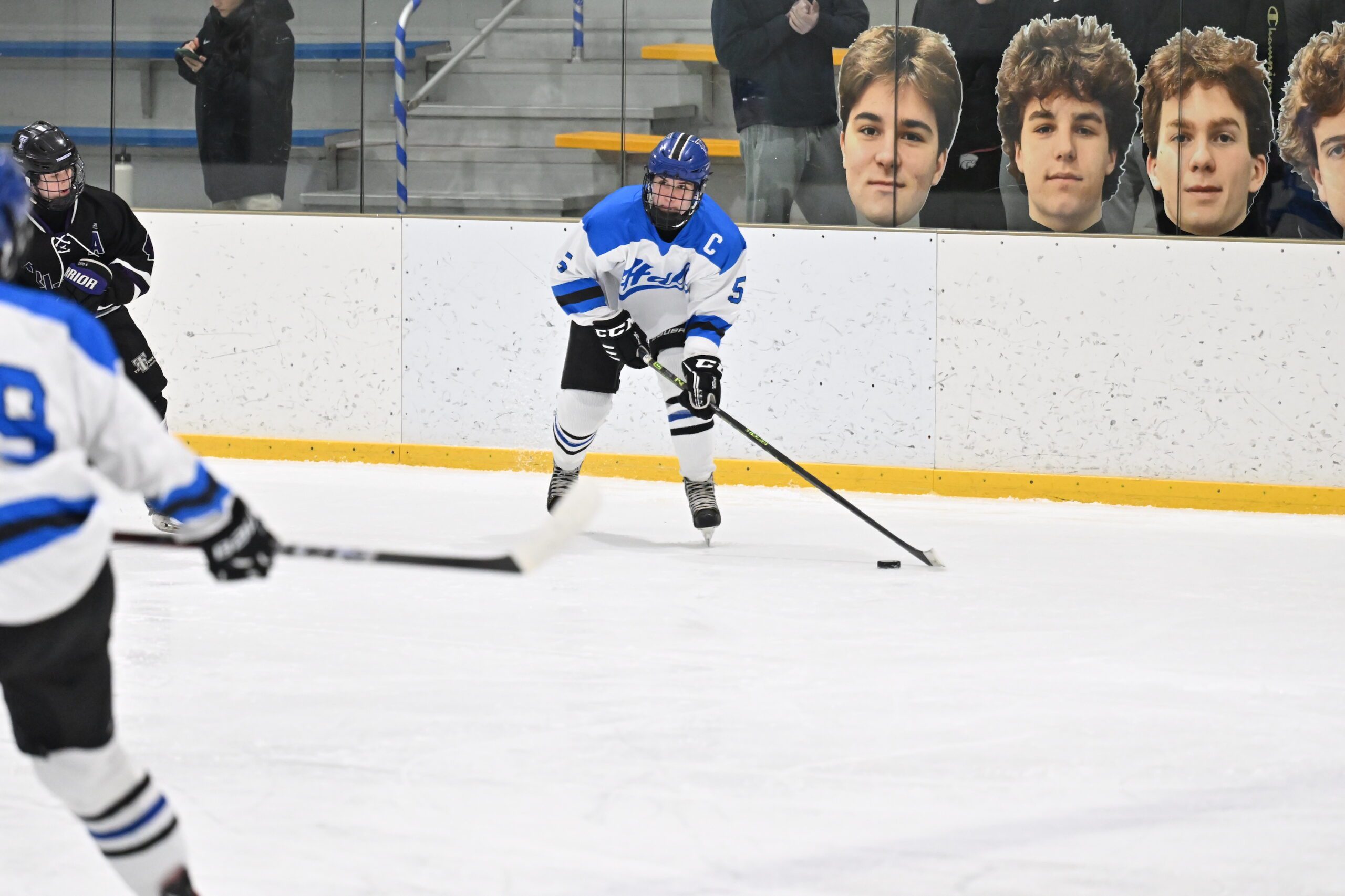 14 Senior Billy DeBassio controls the puck on the ice—while his biggest ...